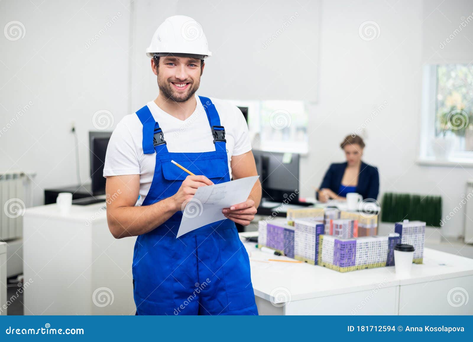 A Young Smiling Construction Worker Taking Notes while in Office Stock ...