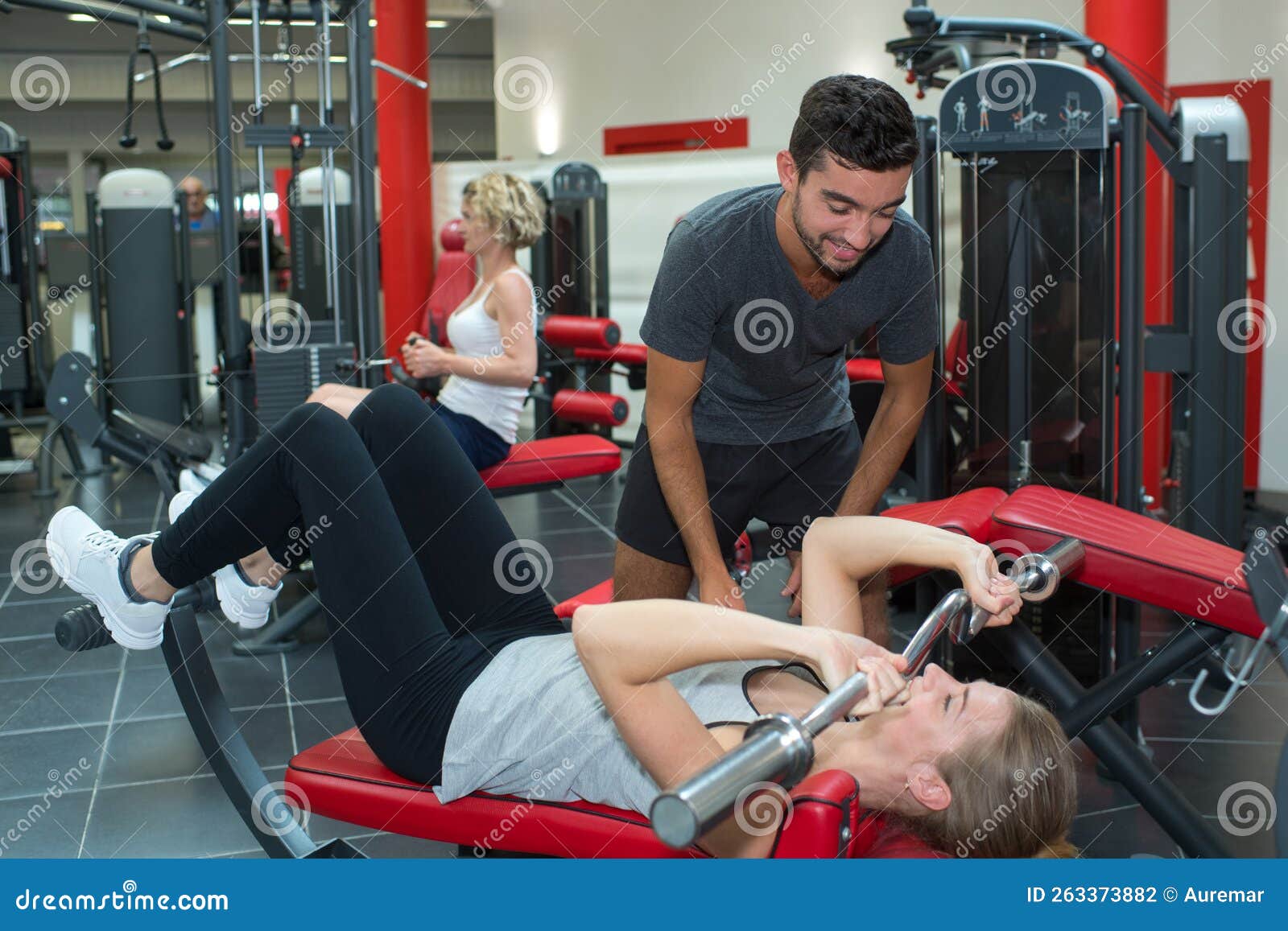 Young Smiling Male Coach Assisting Woman Using Fly Machine Stock Photo ...