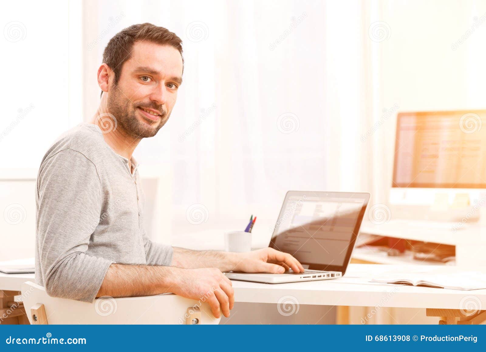 Young Smiling Man in Front of a Computer Stock Photo - Image of smile ...