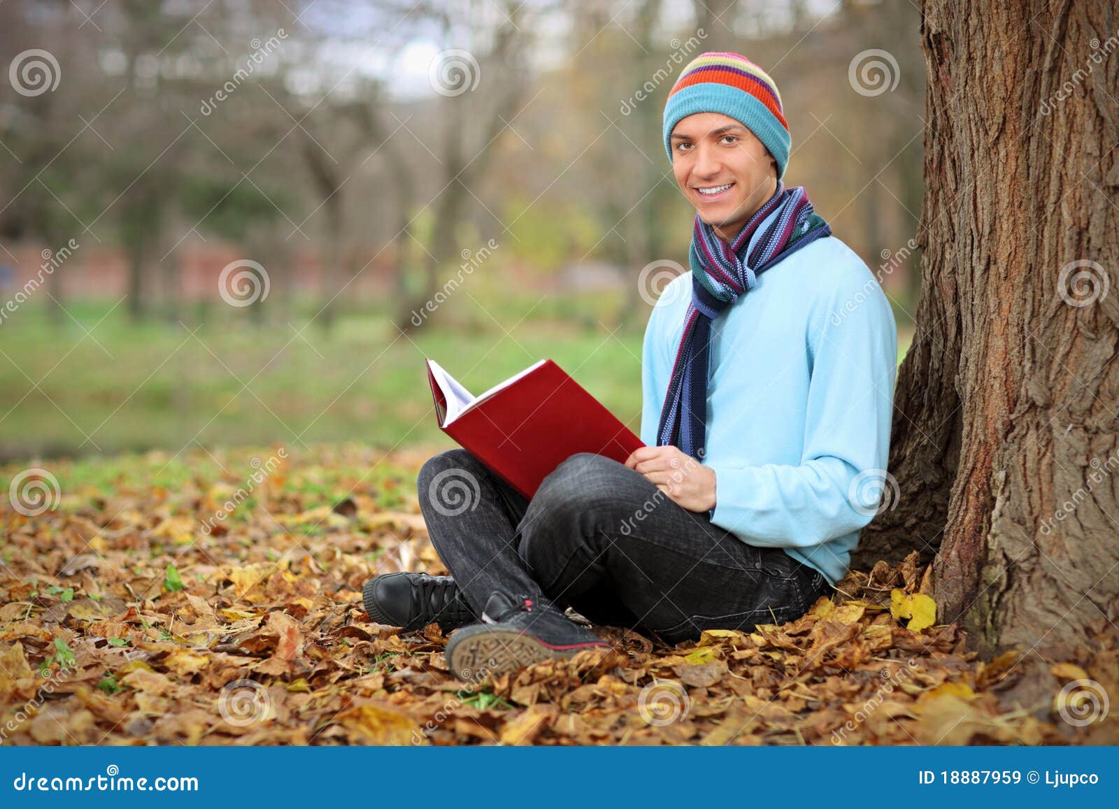 Young Smiling Man Reading a Book in the City Park Stock Image - Image ...