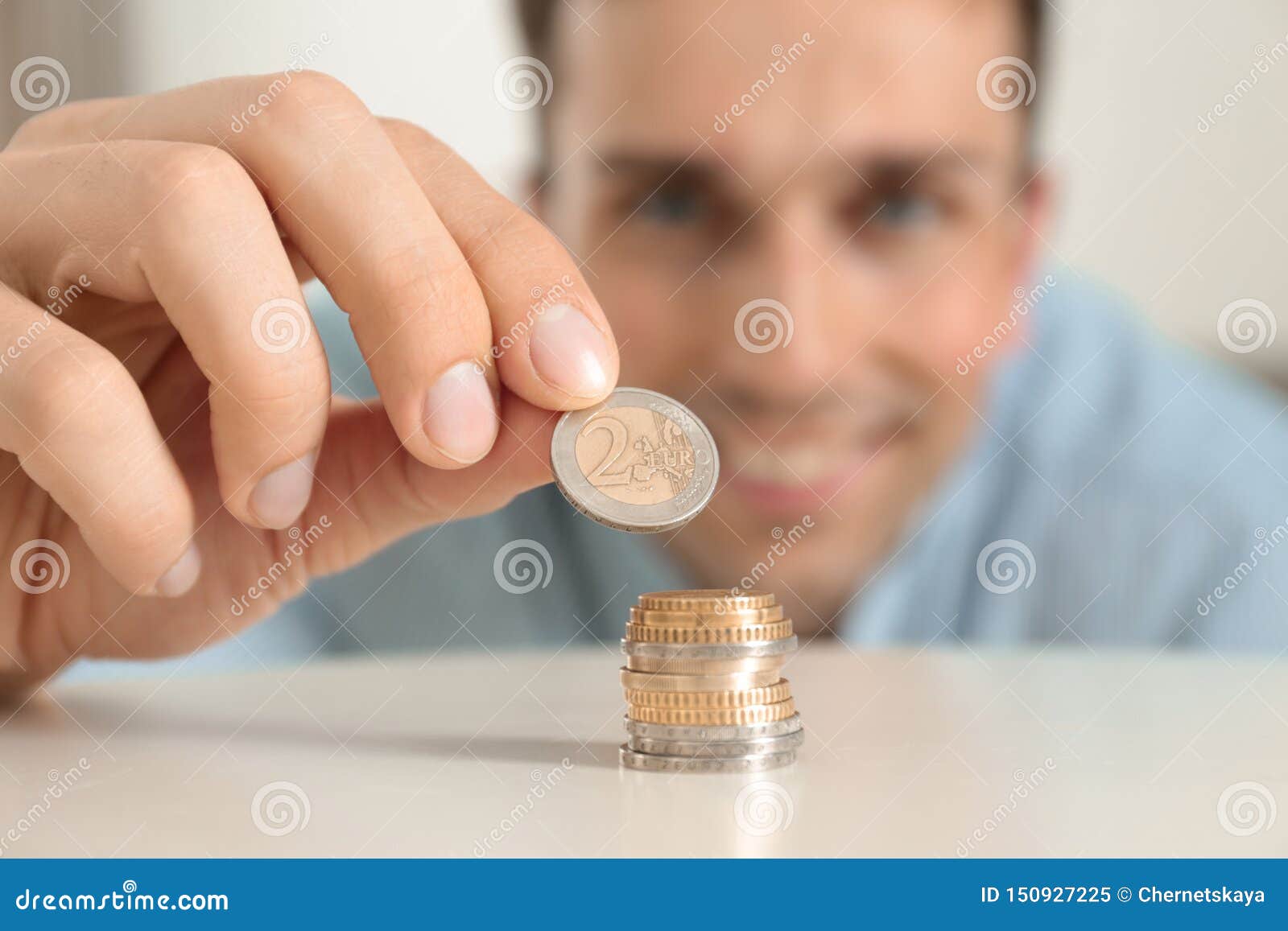 Young Smiling Man Stacking Coins at Table Stock Image - Image of ...