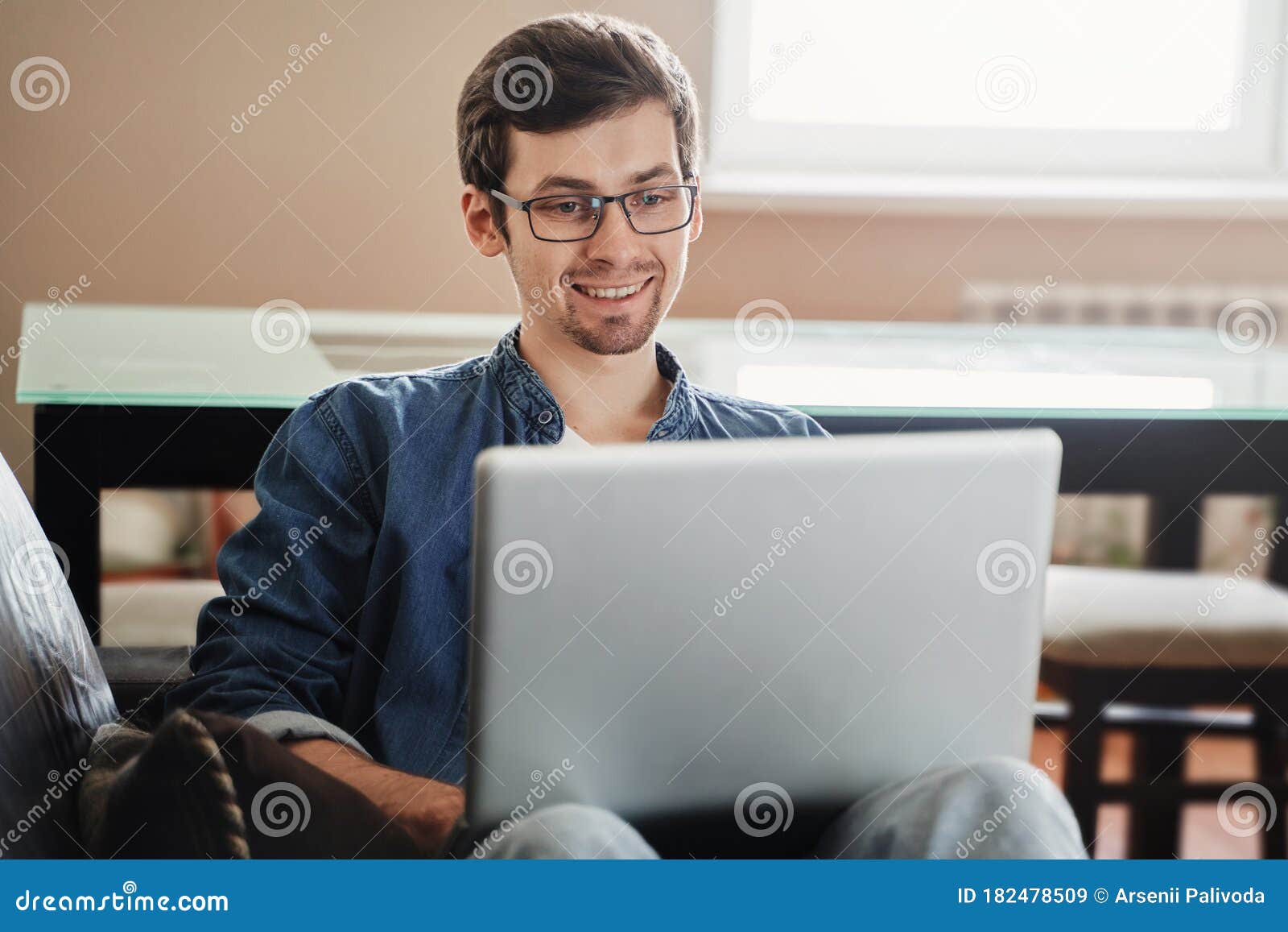 Young Smiling Man is Using Laptop for Remote Work from Home Stock Image ...