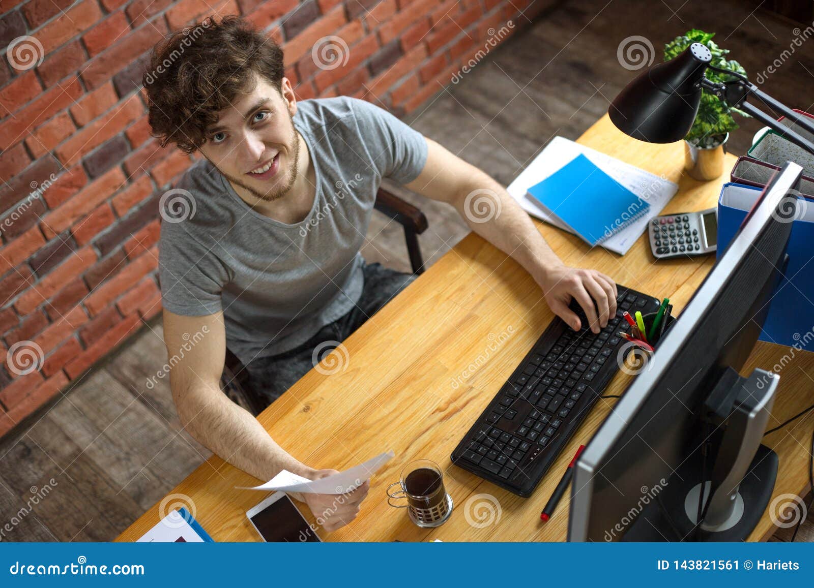 Young Smiling Man Writing with a Marker at His Workplace in Loft Style ...