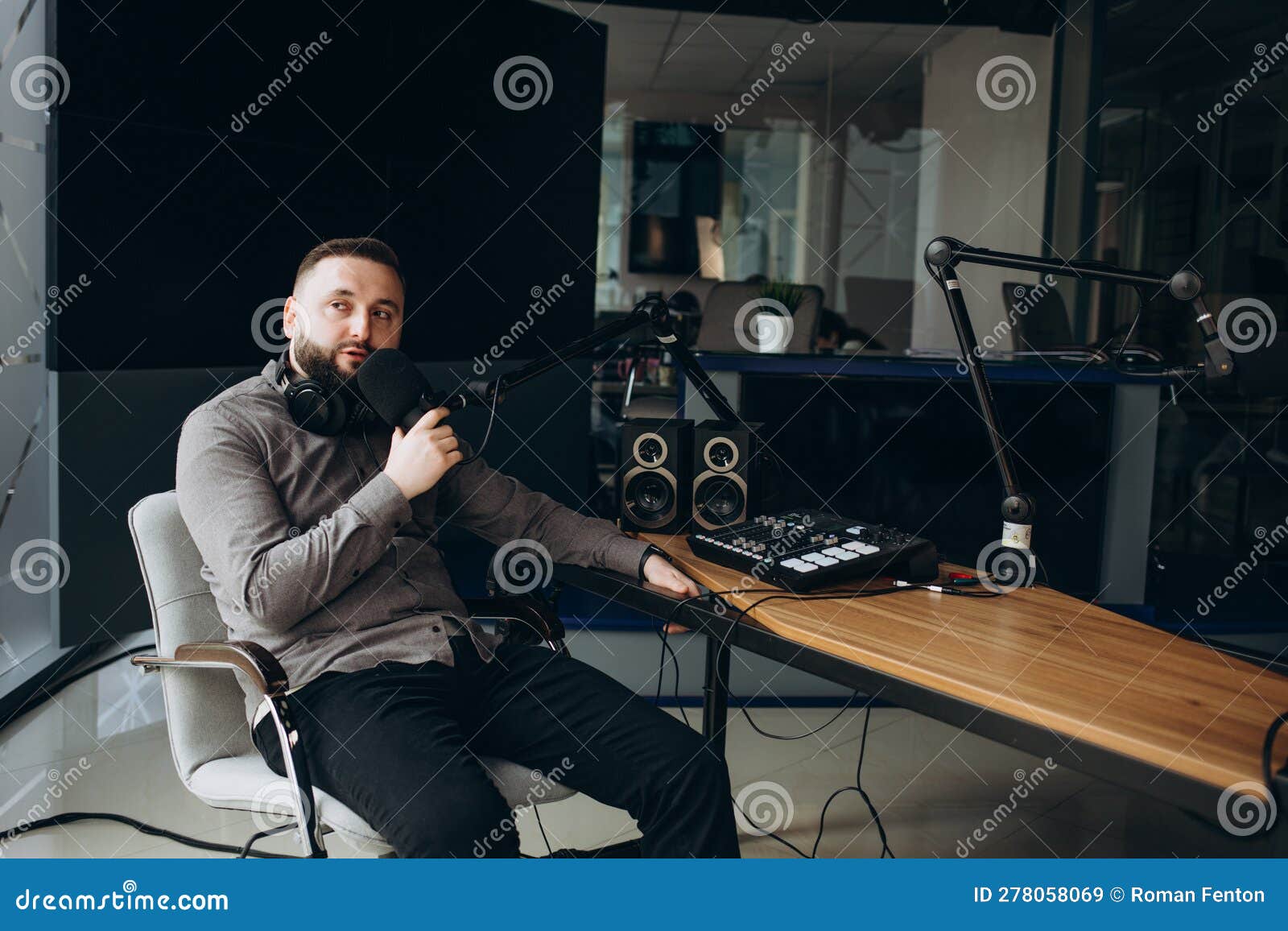 Young Smiling Radio Host Talking into a Microphone and Broadcasting in ...