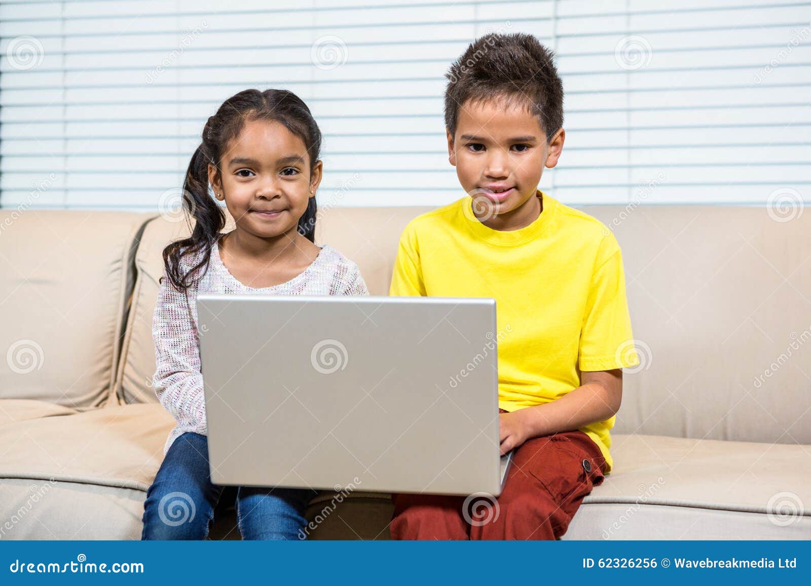 Young Smiling Siblings Using Laptop Stock Photo - Image of domestic ...