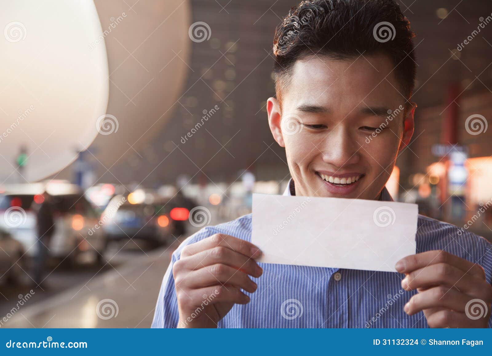 Young Smiling Traveler Looking at Ticket at Airport Stock Photo - Image ...