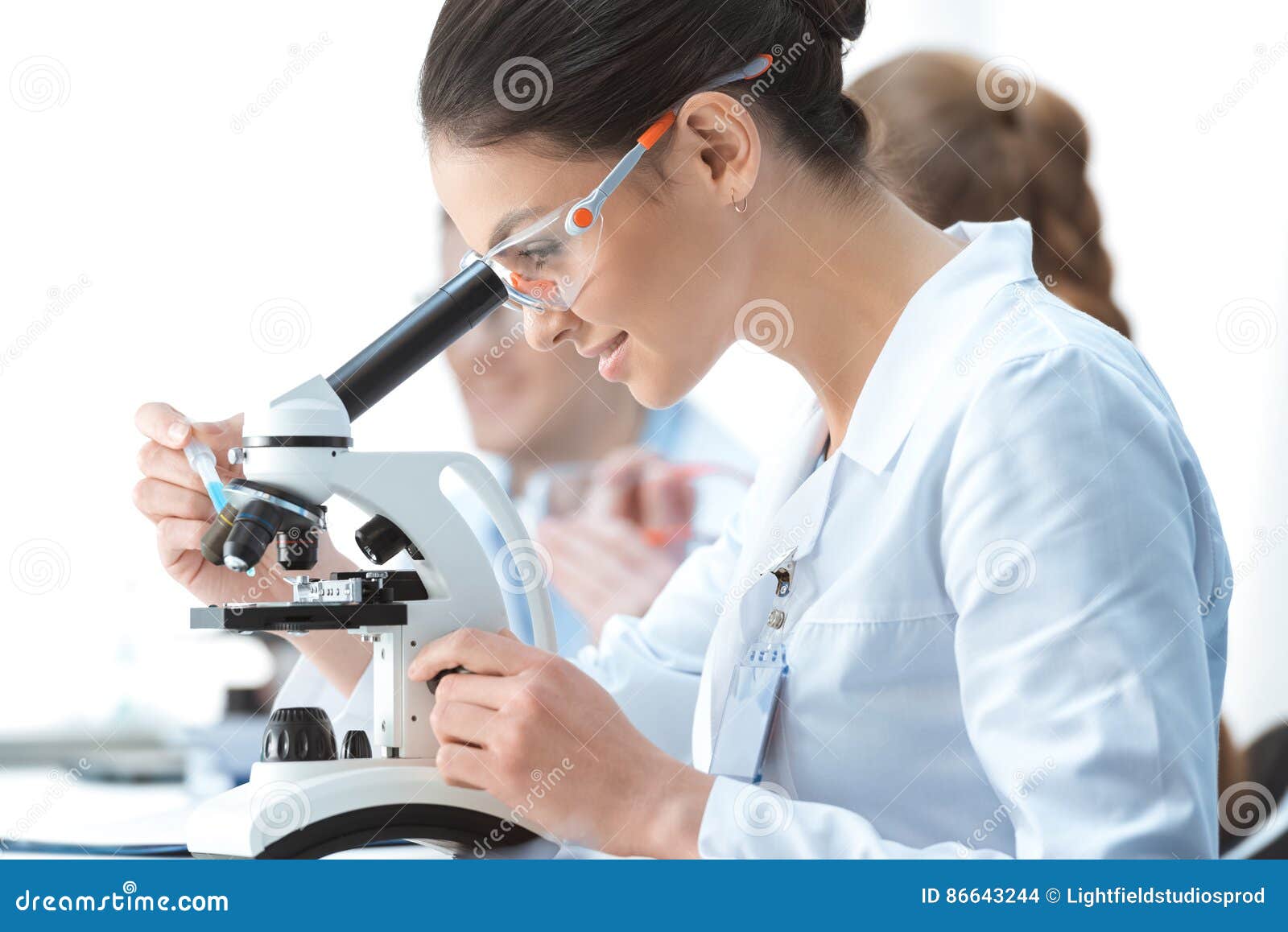 Young Smiling Woman Scientist Working with Microscope Stock Photo ...