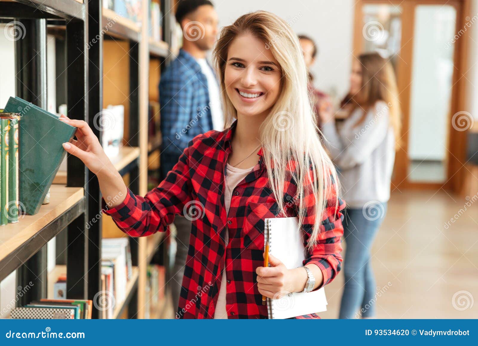 Young Smiling Woman Student Standing in Library Holding Book. Stock ...
