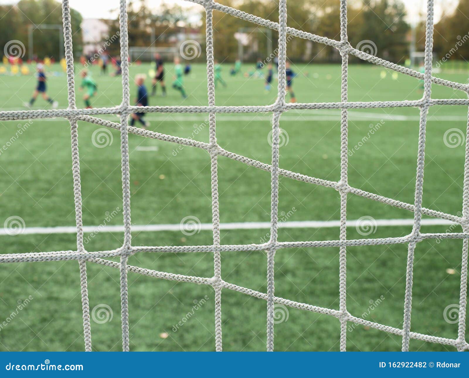 Young Soccer Team on Playground Viewed through Net Stock Photo - Image ...