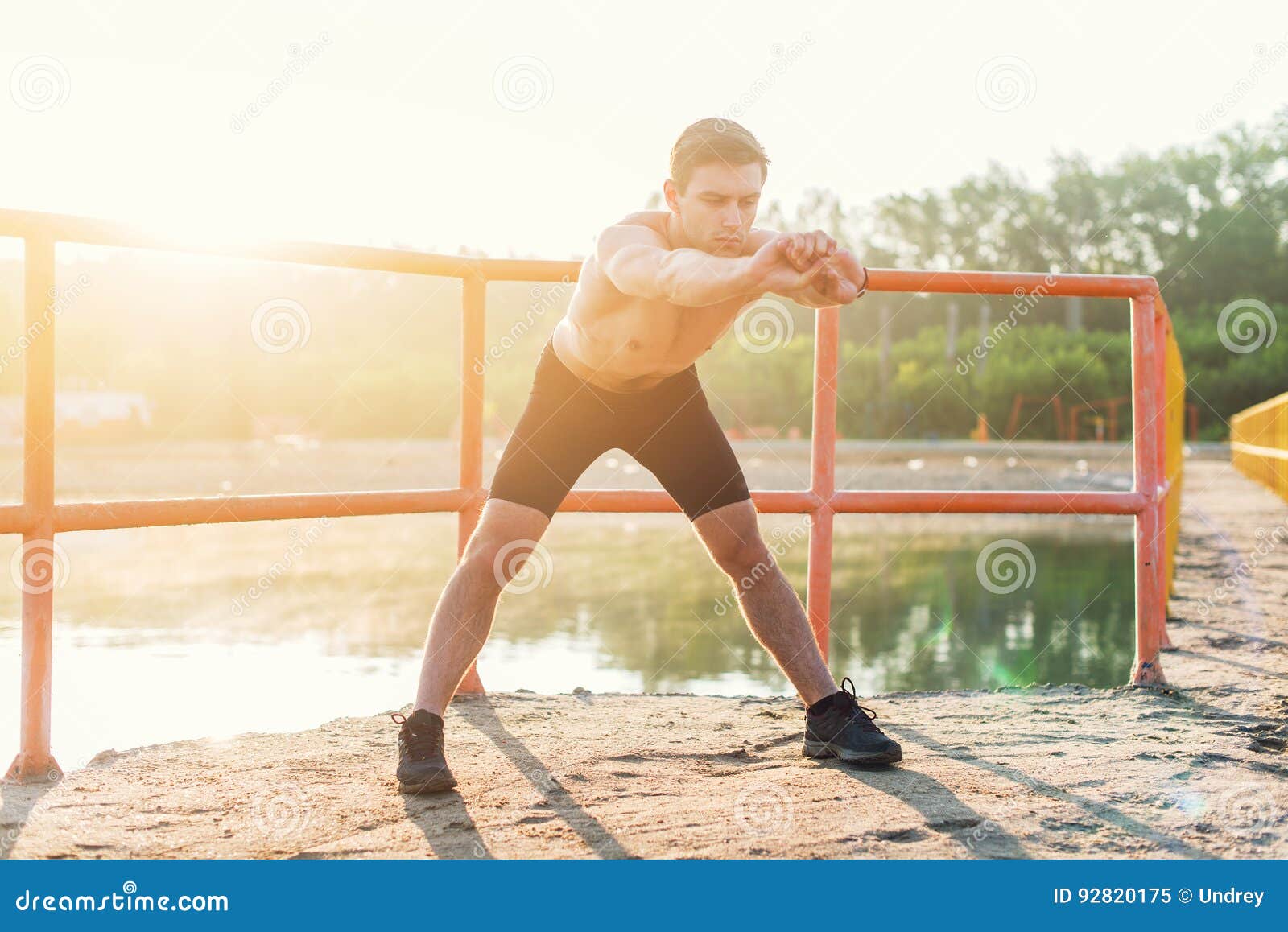 Young Sporty Man Bending Forward and Doing Stretching Exercise. Stock ...