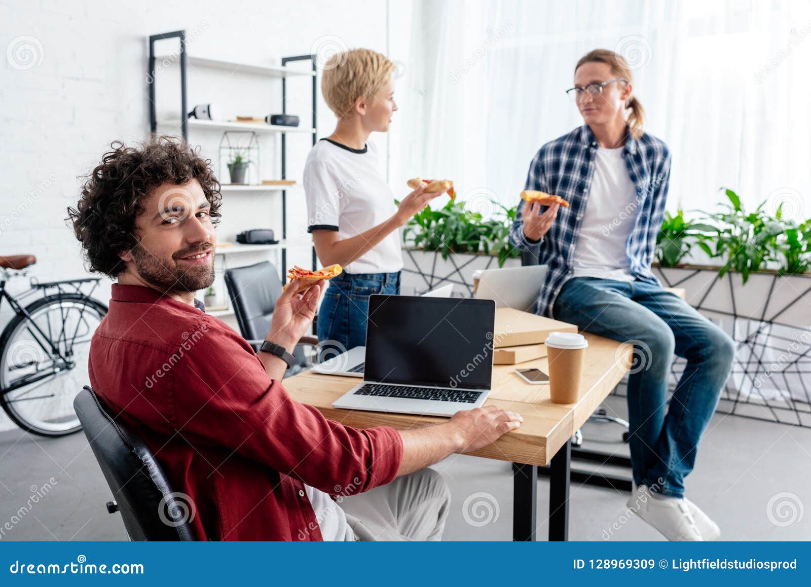 Young Start Up Team Eating Pizza Together while Working Stock Image ...