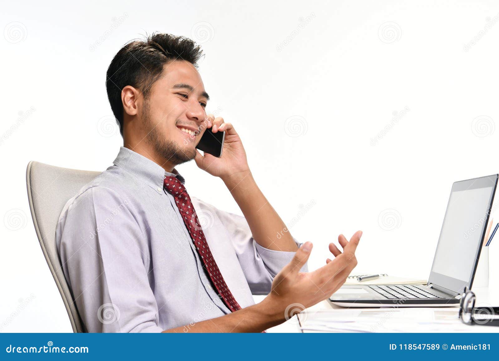 Young Business Man Smiling while Talking on the Phone and Working with ...