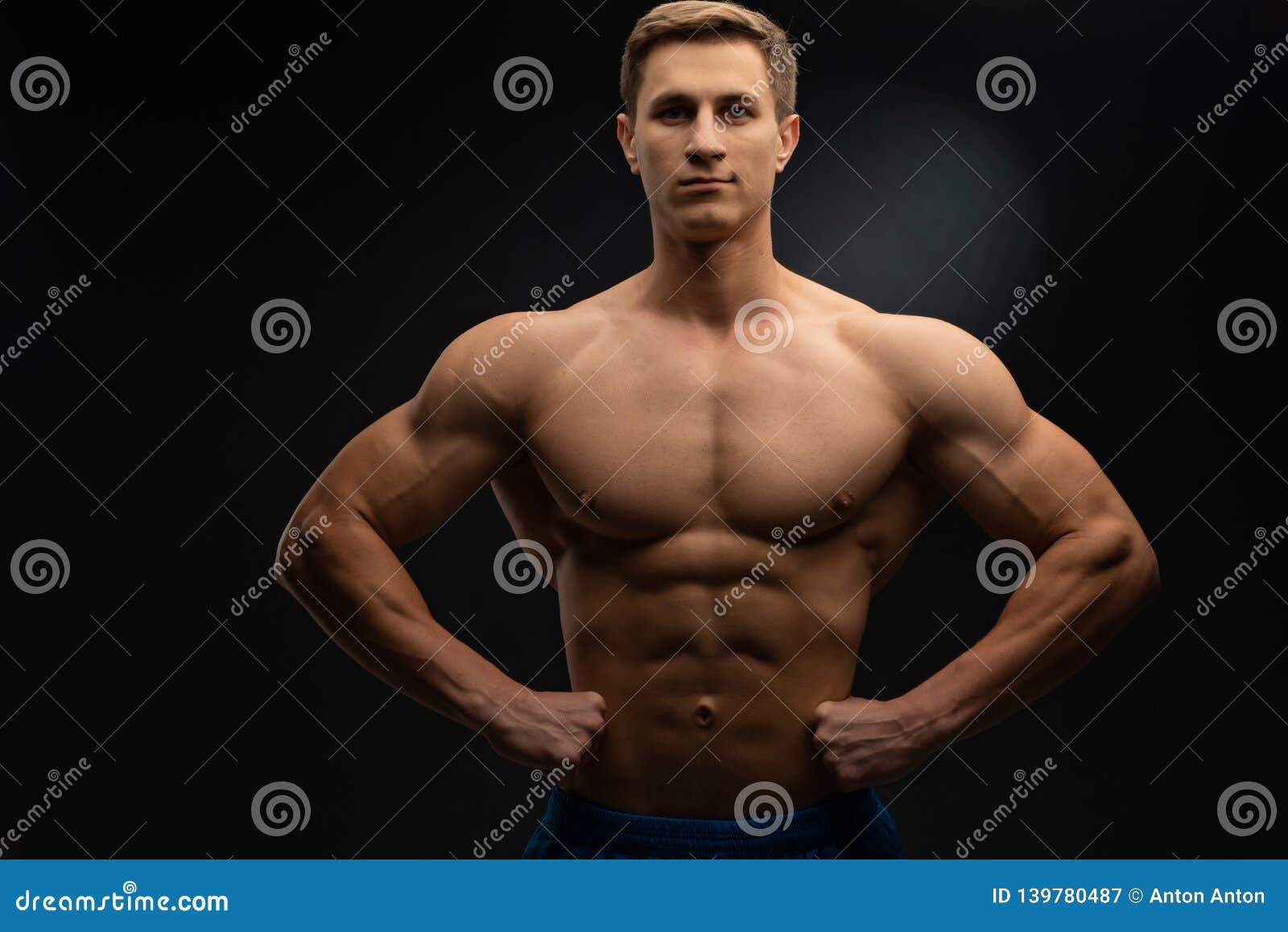 Young, Strong Bodybuilder with Six Packs. Bodybuilder Flexes Muscles ...