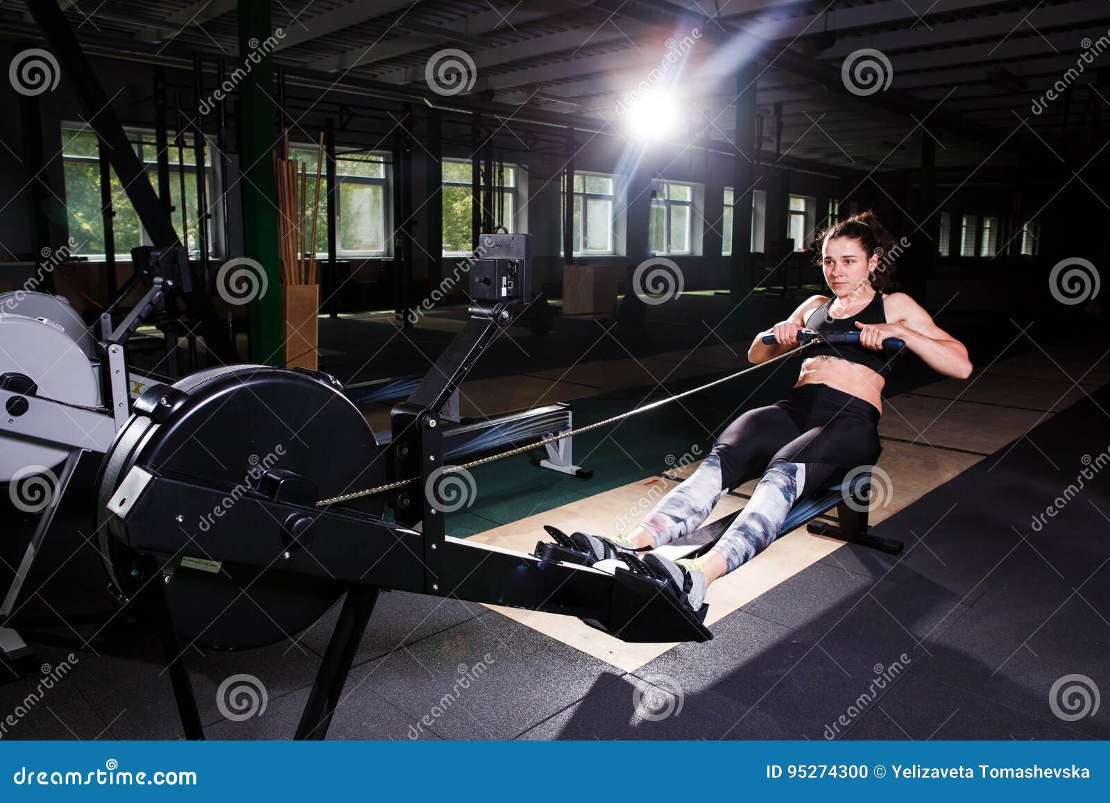 Young Strong Girl Doing an Exercise on a Rowing Machine. for Training ...