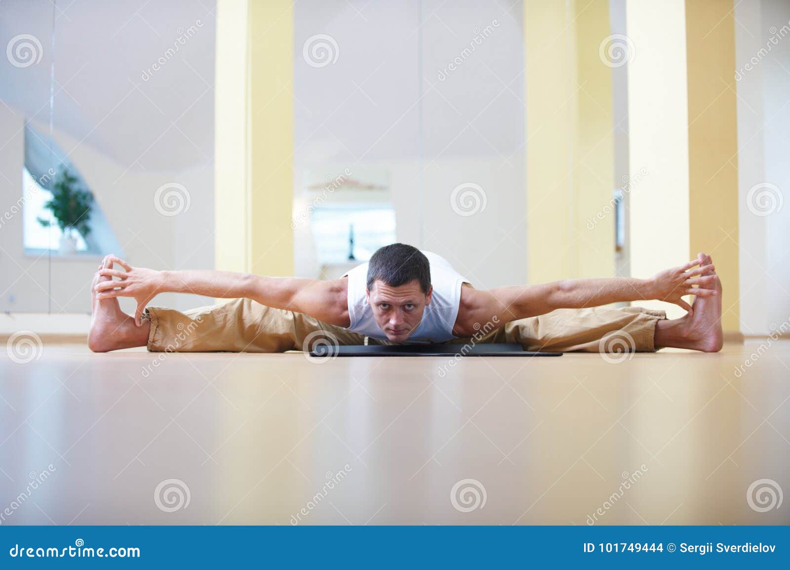 A Young Strong Man Doing Yoga Exercises -Samakonasana Straight Angle ...