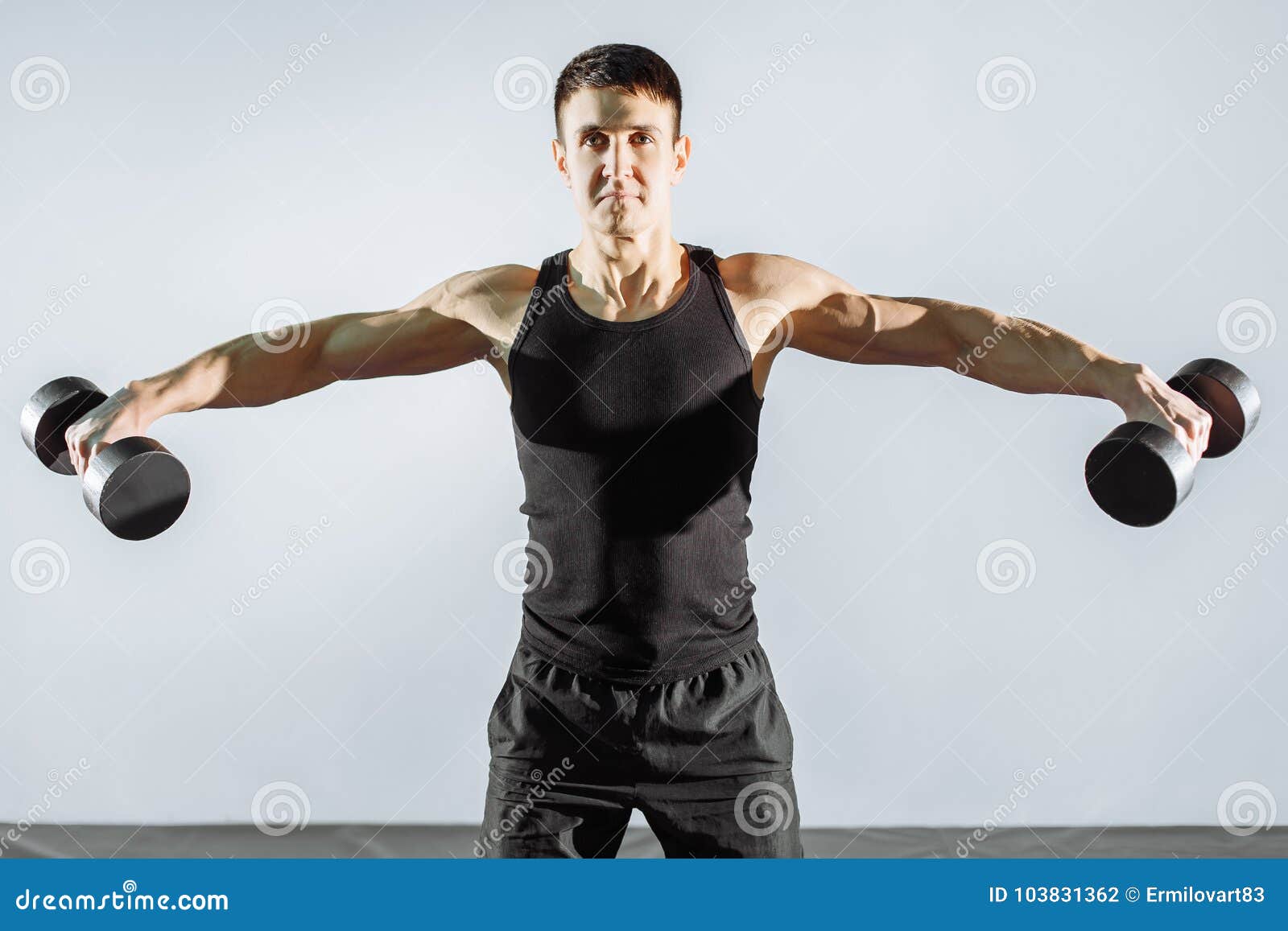 Young Strong Man Exercising with Dumbbells in Gym. Stock Photo - Image ...