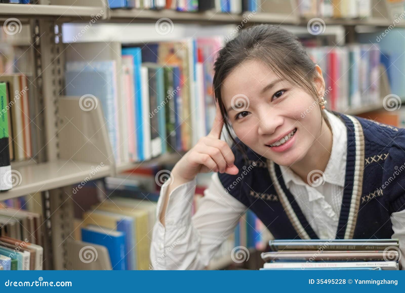 Young Student Holding Books Near Bookshelf Stock Photo - Image of ...