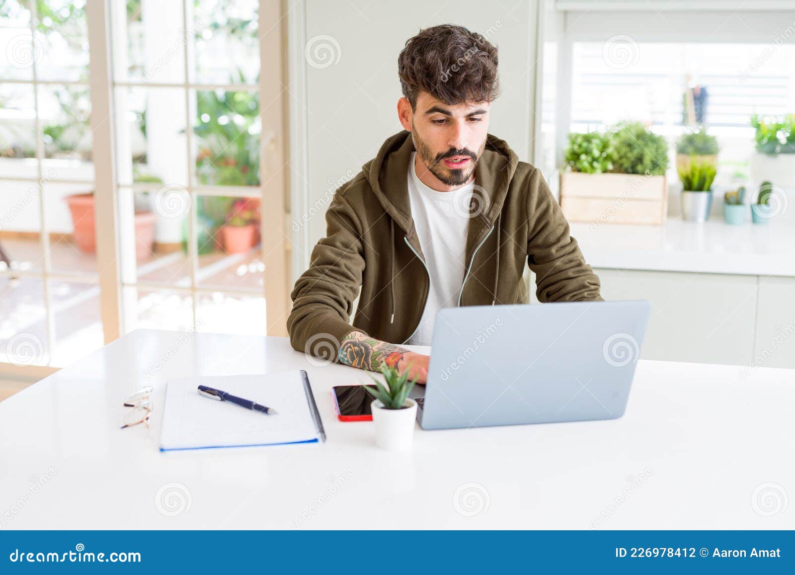 Young Student Man Using Computer Laptop and Notebook Scared in Shock ...