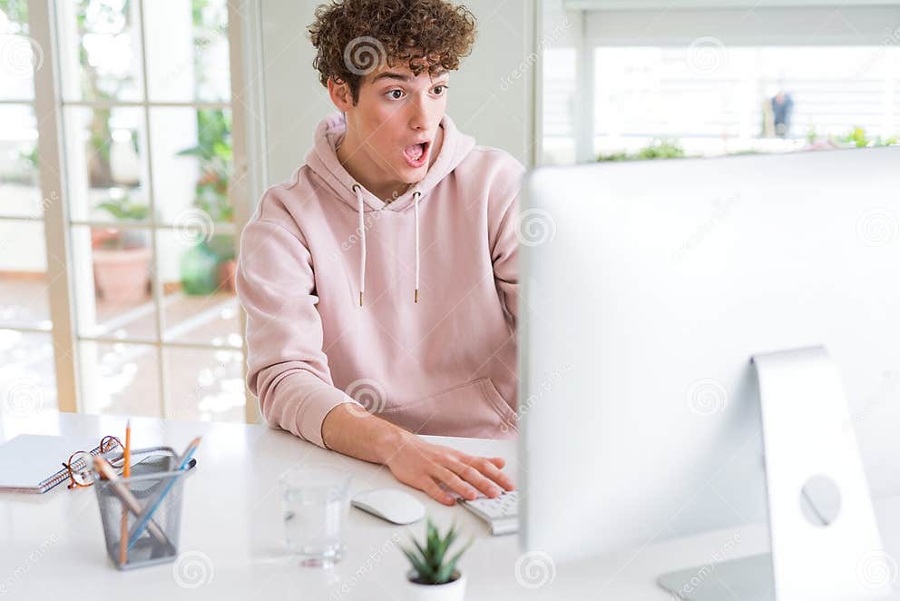 Young Student Man Using Computer Scared in Shock with a Surprise Face ...