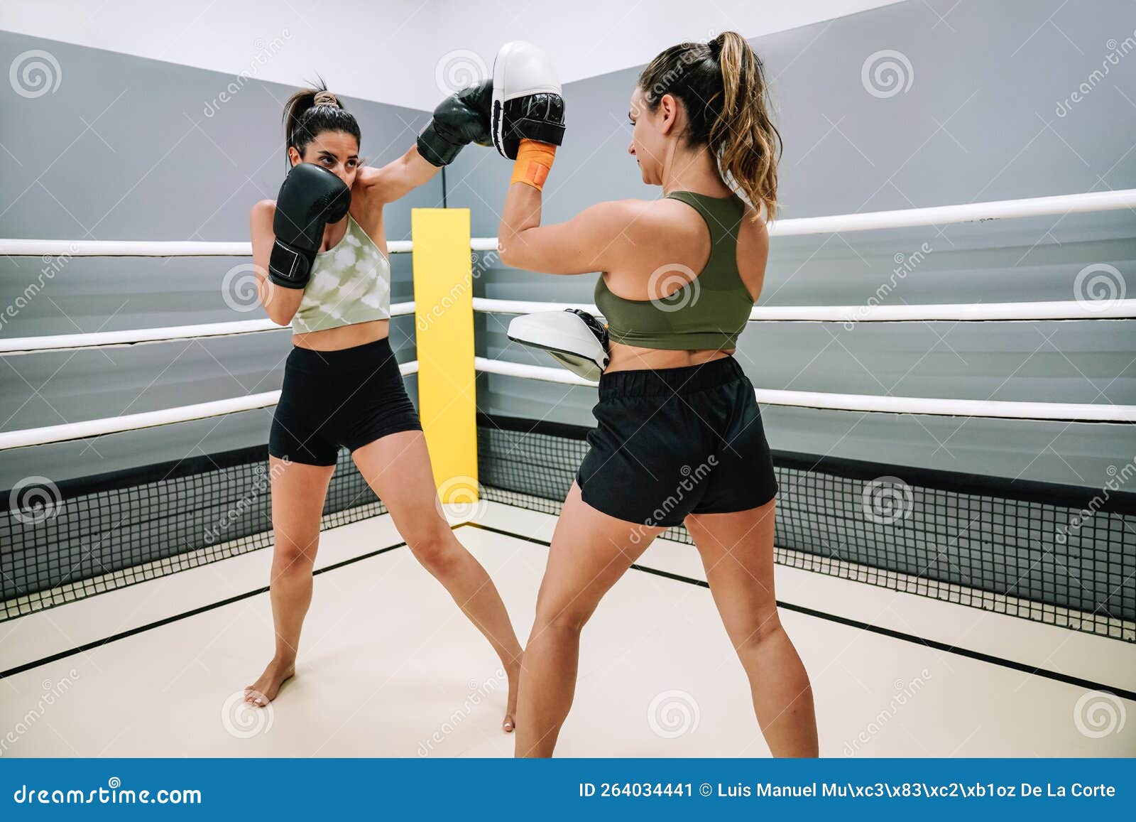 A Young Student Practicing Punching with Her Trainer in a Kickboxing ...