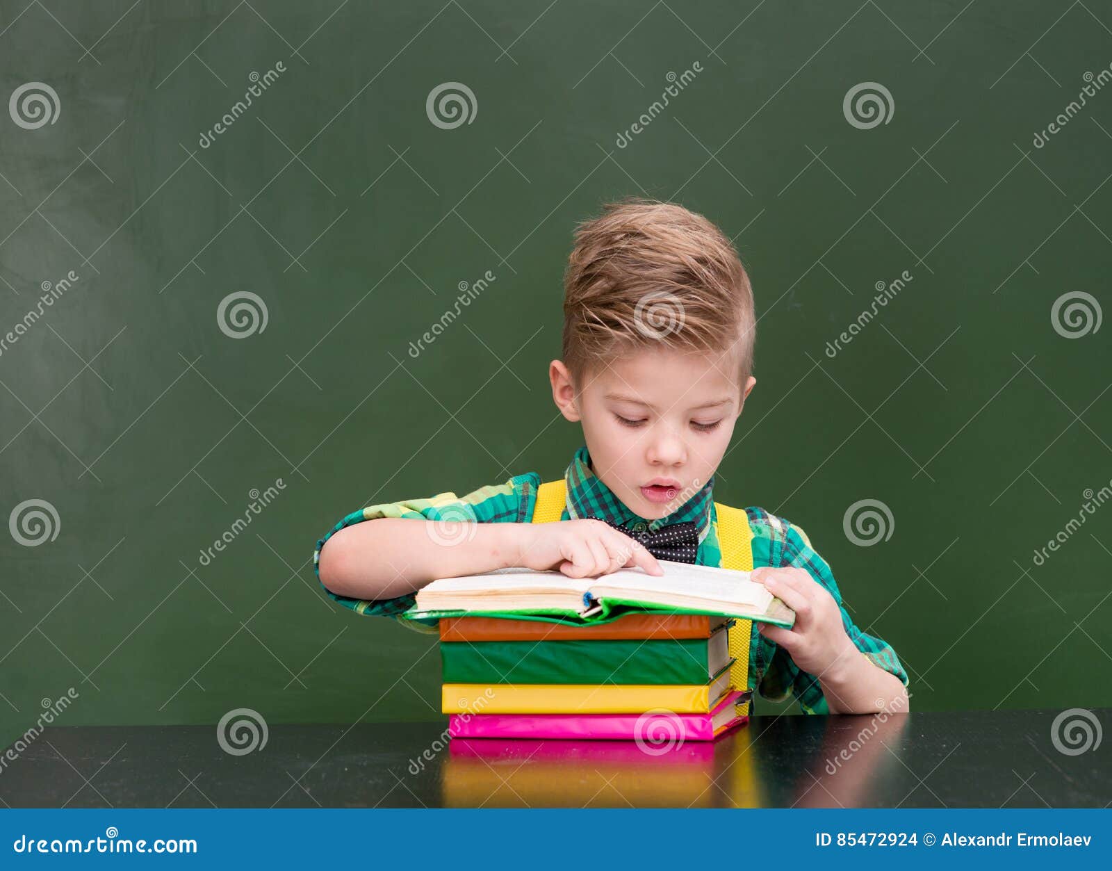 Young Student Reading a Book Near Empty Green Chalkboard Stock Photo ...