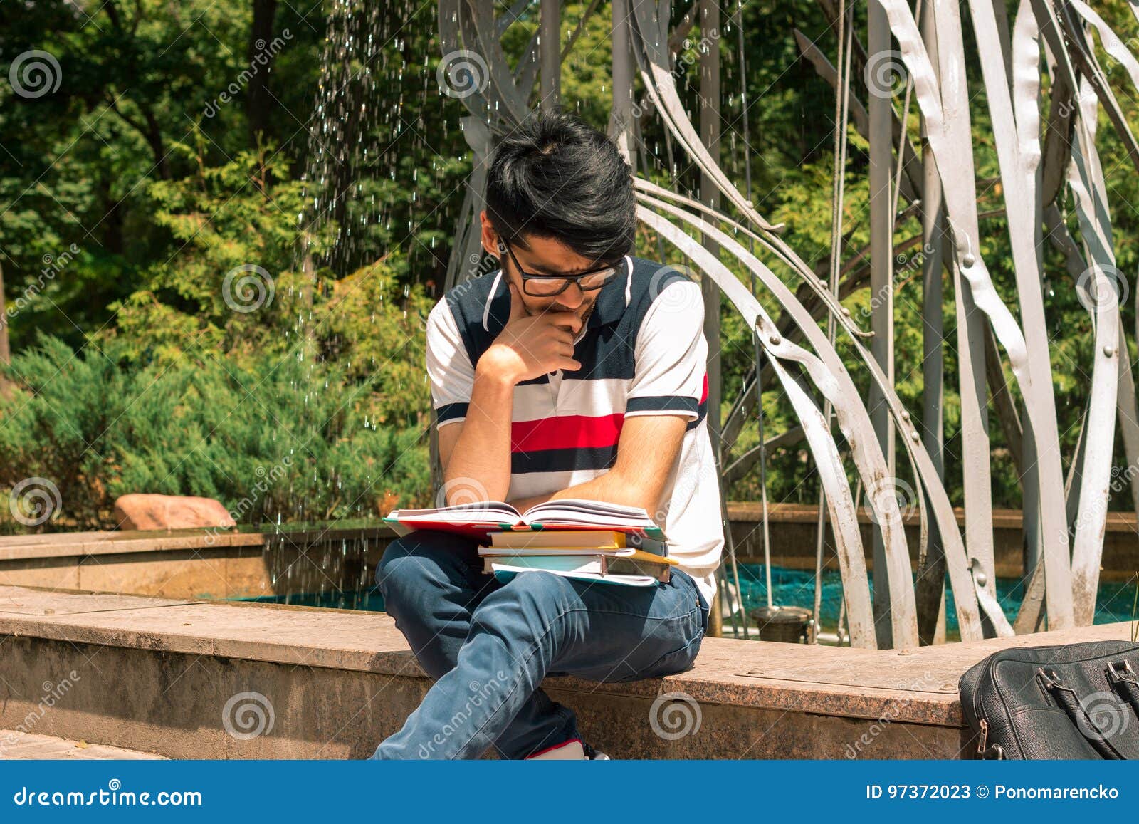 Young Student Sits on a Bench and Reads Books Stock Image - Image of ...