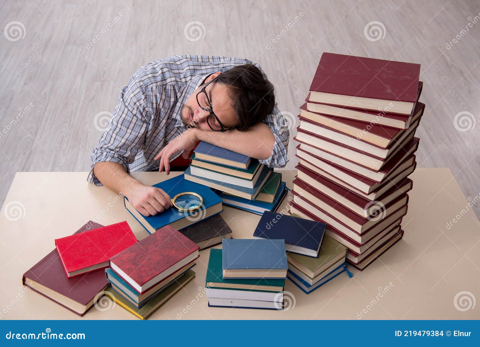 Young Male Student and Too Many Books in the Classroom Stock Photo ...