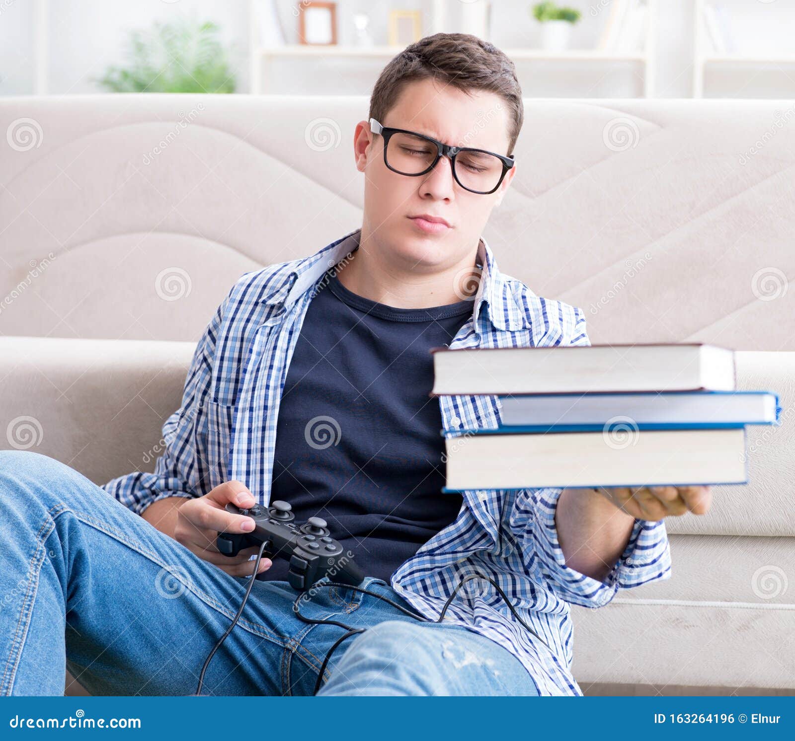 Young Student Trying To Balance Studying and Playing Games Stock Photo ...