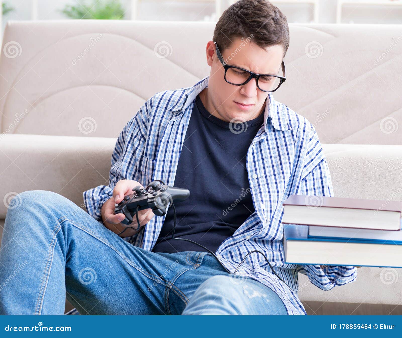 Young Student Trying To Balance Studying and Playing Games Stock Photo ...