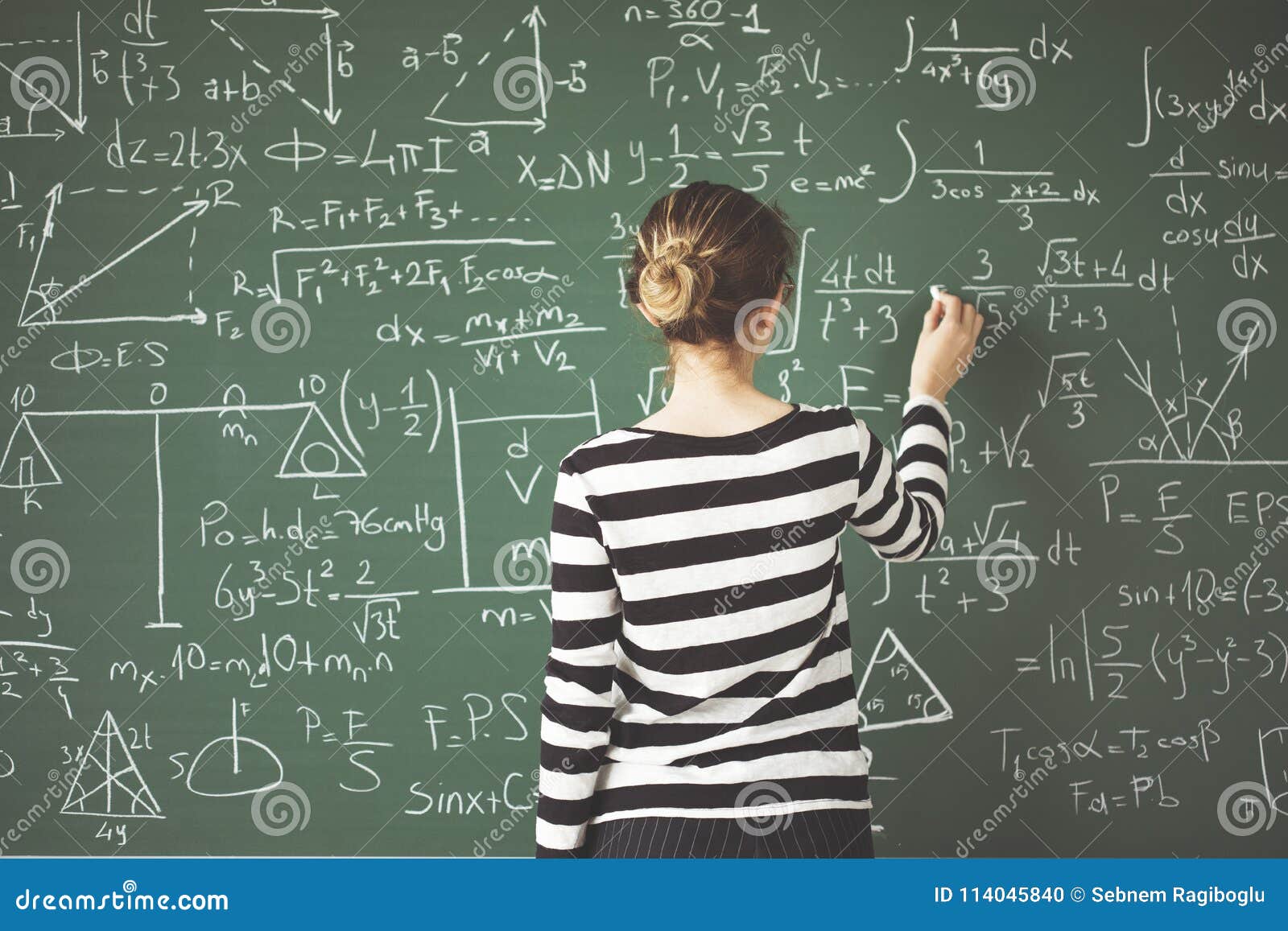Young Student Writing with Chalk on Green Chalk Board in Classroom ...