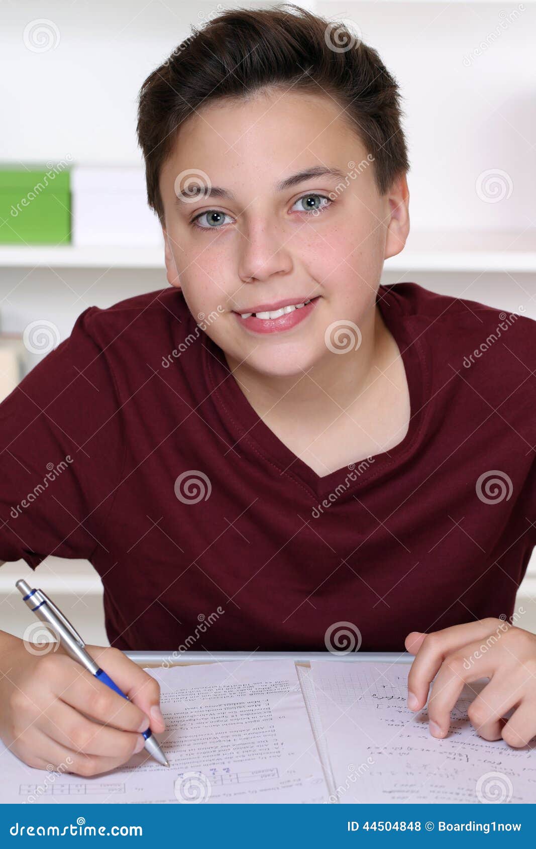 Young Student Writing in His Exercise Book at School Stock Photo ...