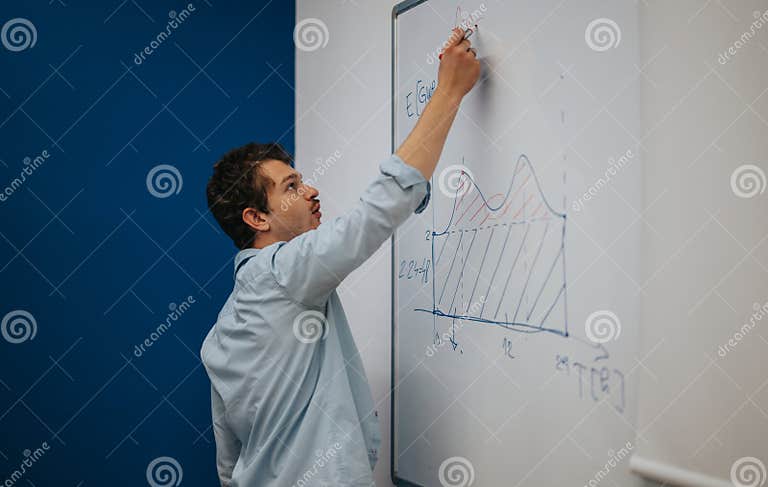 Young Student Writing Mathematical Equations on Whiteboard in Classroom ...