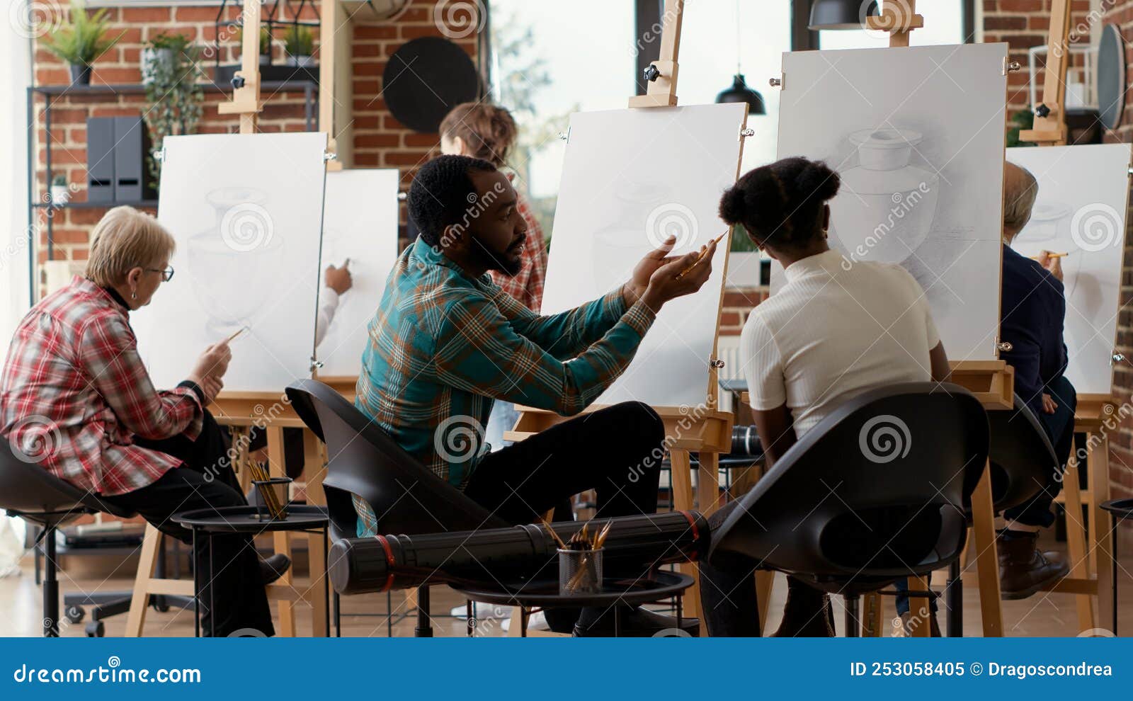 Young Students Drawing on Canvas and Talking about Artwork Stock Image ...