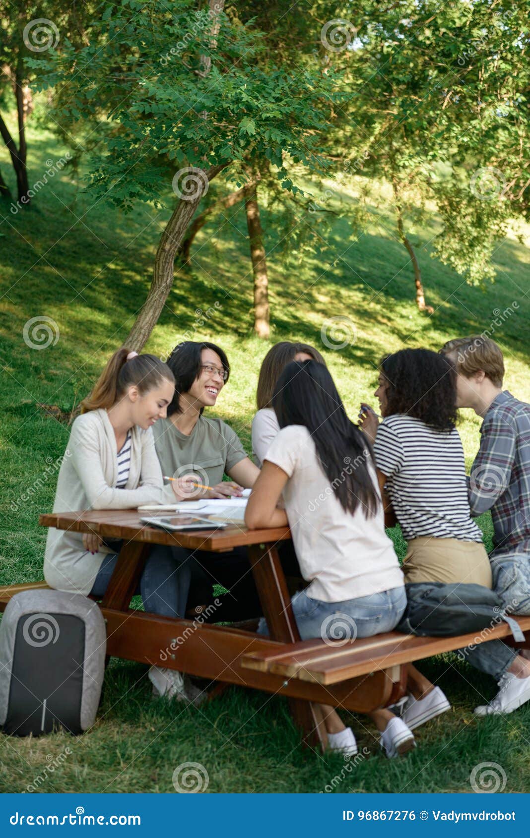 Young Students Sitting and Studying Outdoors while Talking. Stock Photo ...