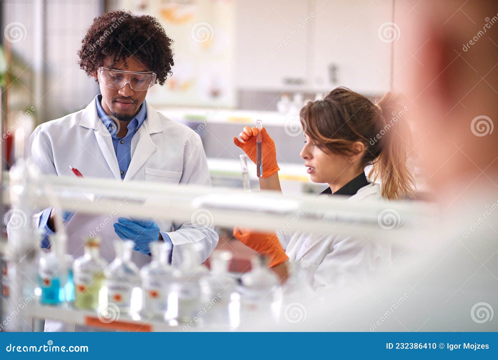 Young Students Taking Notes about Experiment in the Laboratory. Science ...
