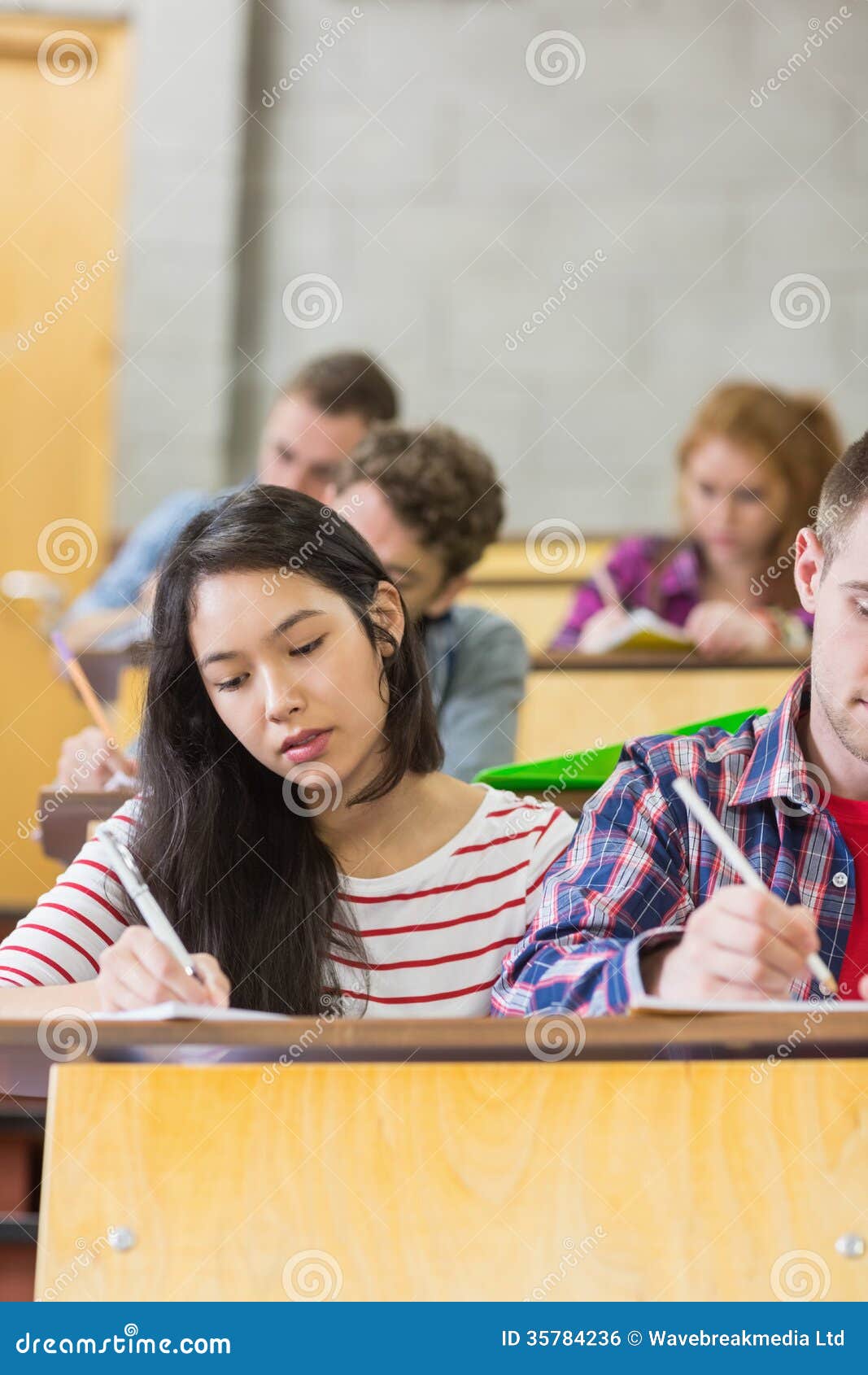 Young Students Writing Notes in Classroom Stock Photo - Image of ...