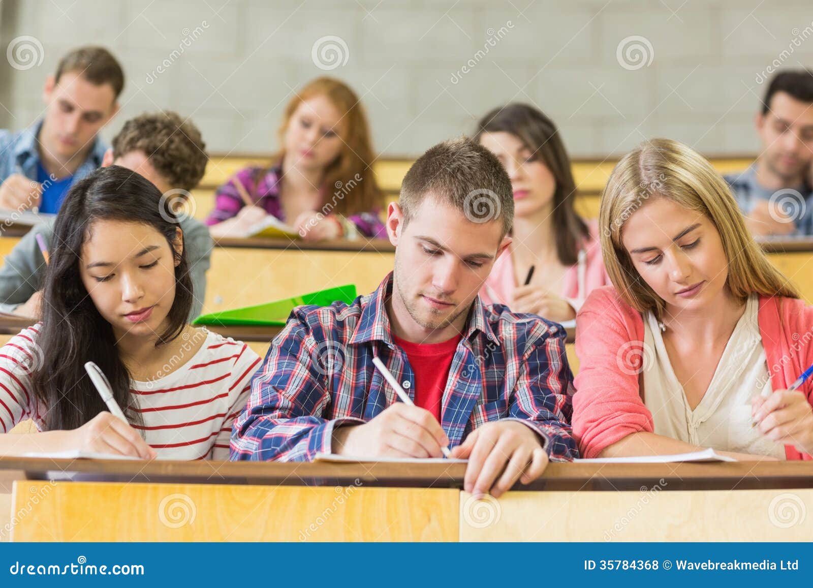 Young Students Writing Notes in the Classroom Stock Photo - Image of ...