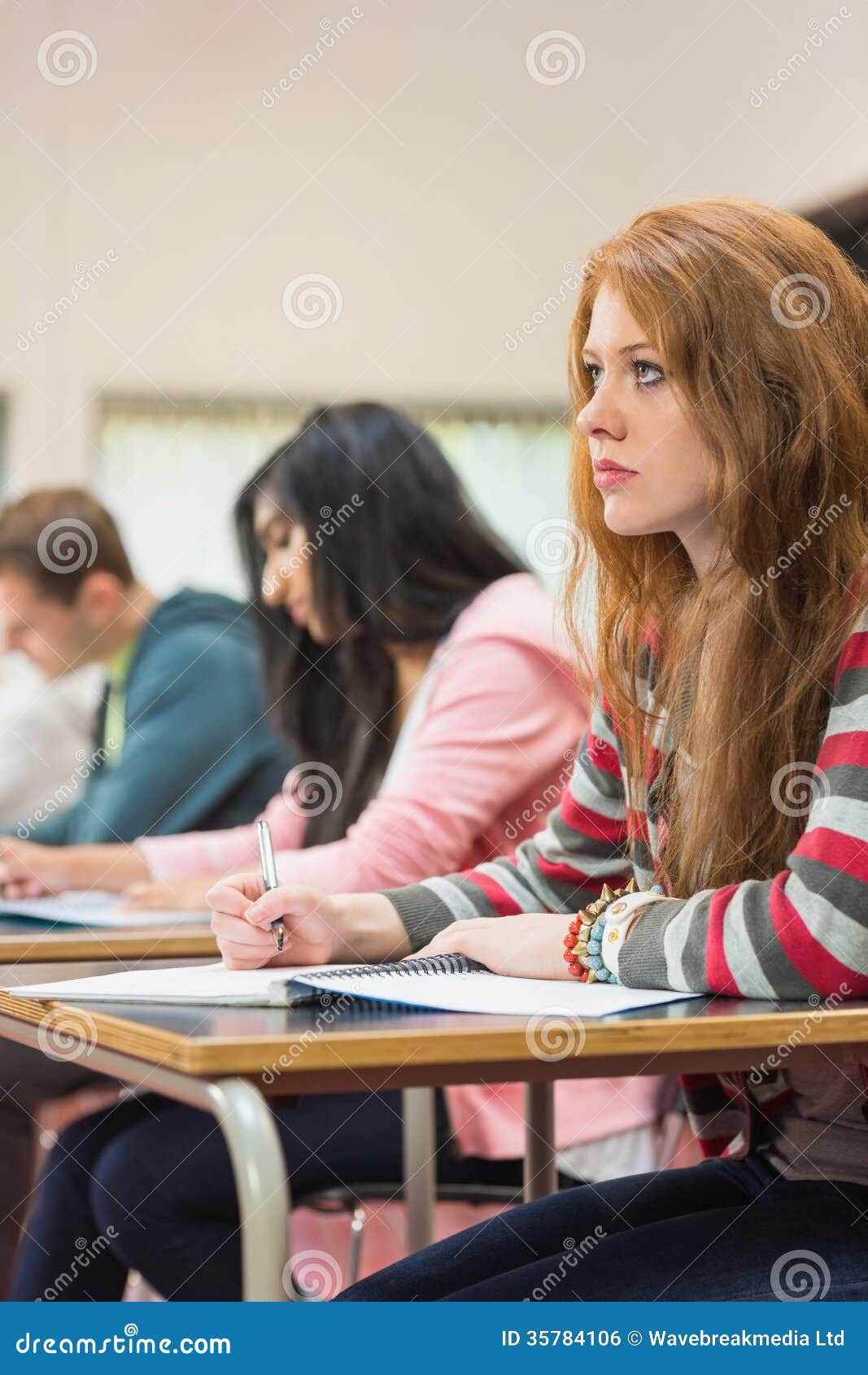 Young Students Writing Notes in Classroom Stock Photo - Image of four ...