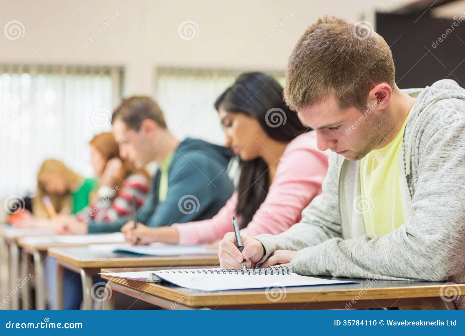 Young Students Writing Notes in Classroom Stock Photo - Image of ...