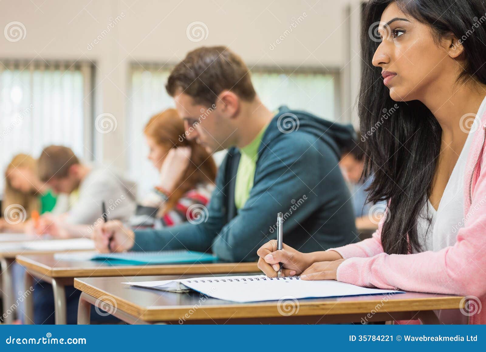Young Students Writing Notes in Classroom Stock Image - Image of medium ...