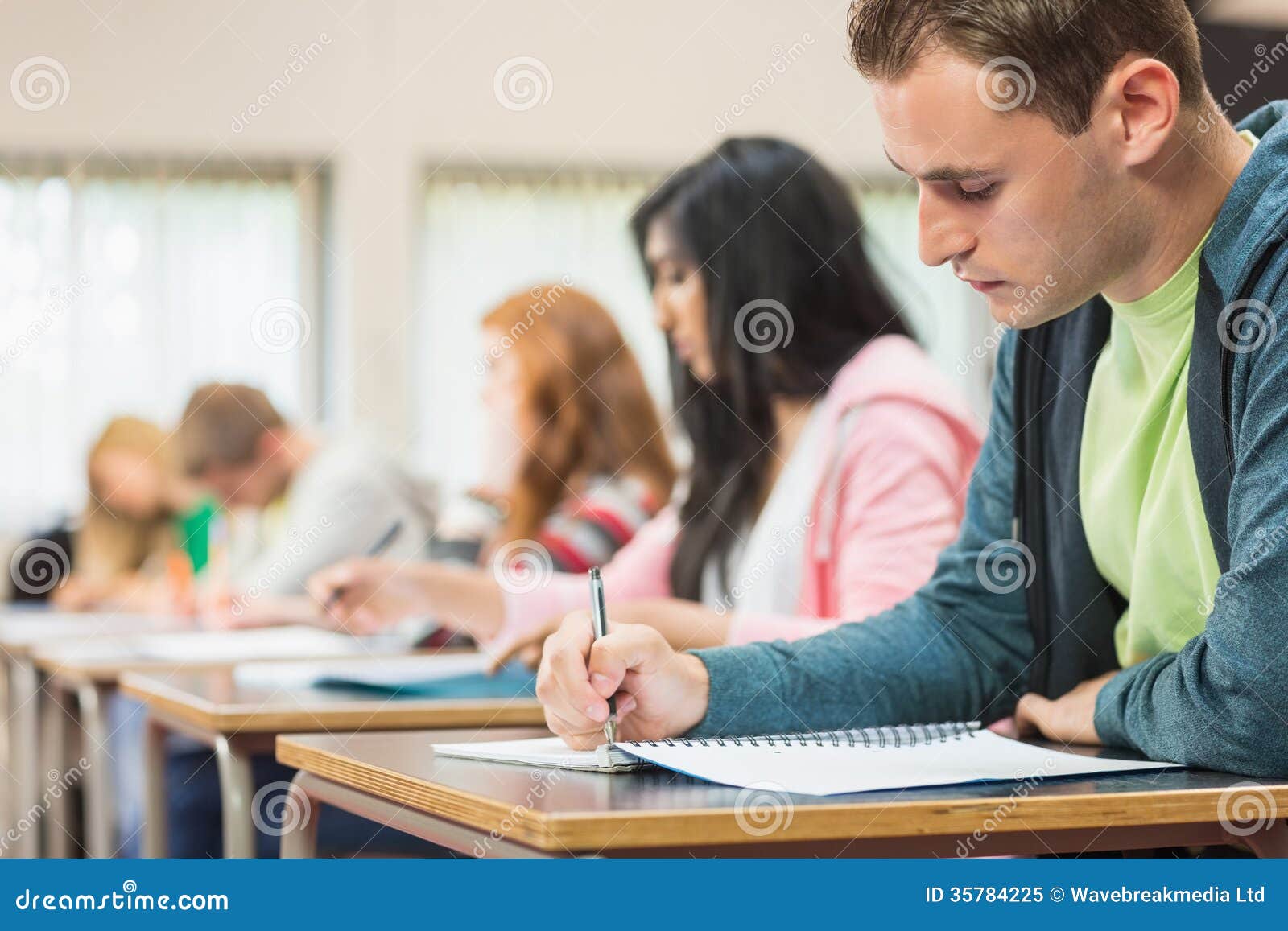 Young Students Writing Notes in Classroom Stock Image - Image of ...