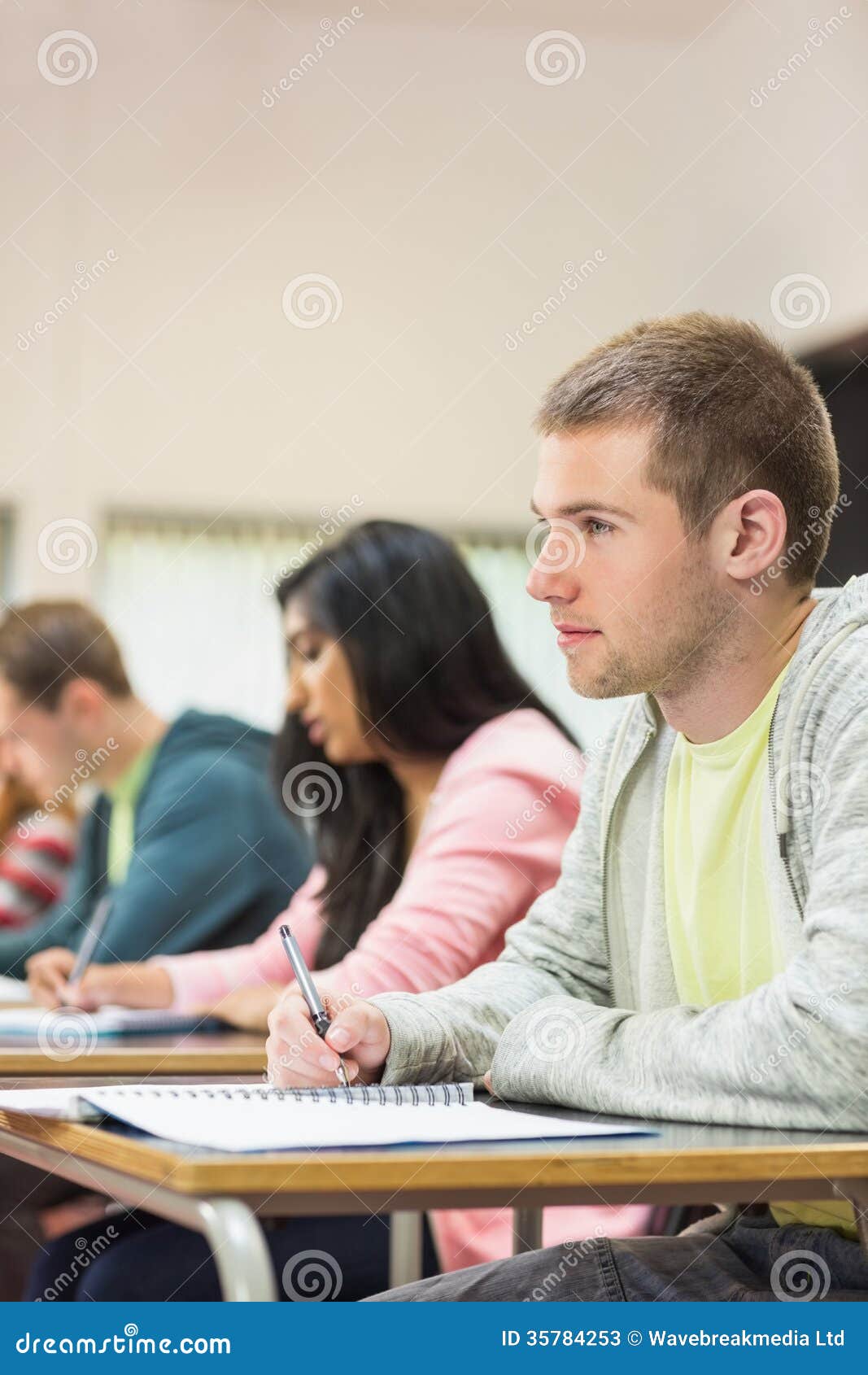 Young Students Writing Notes in Classroom Stock Image - Image of desk ...