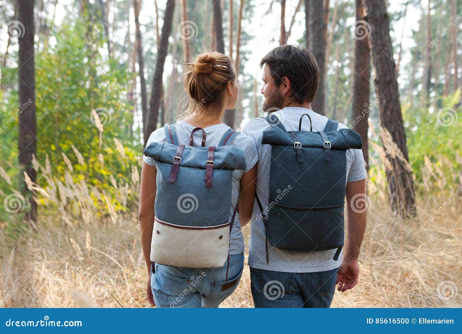 Young Stylish Couple with Backpacks Hugging in Forest Stock Photo ...