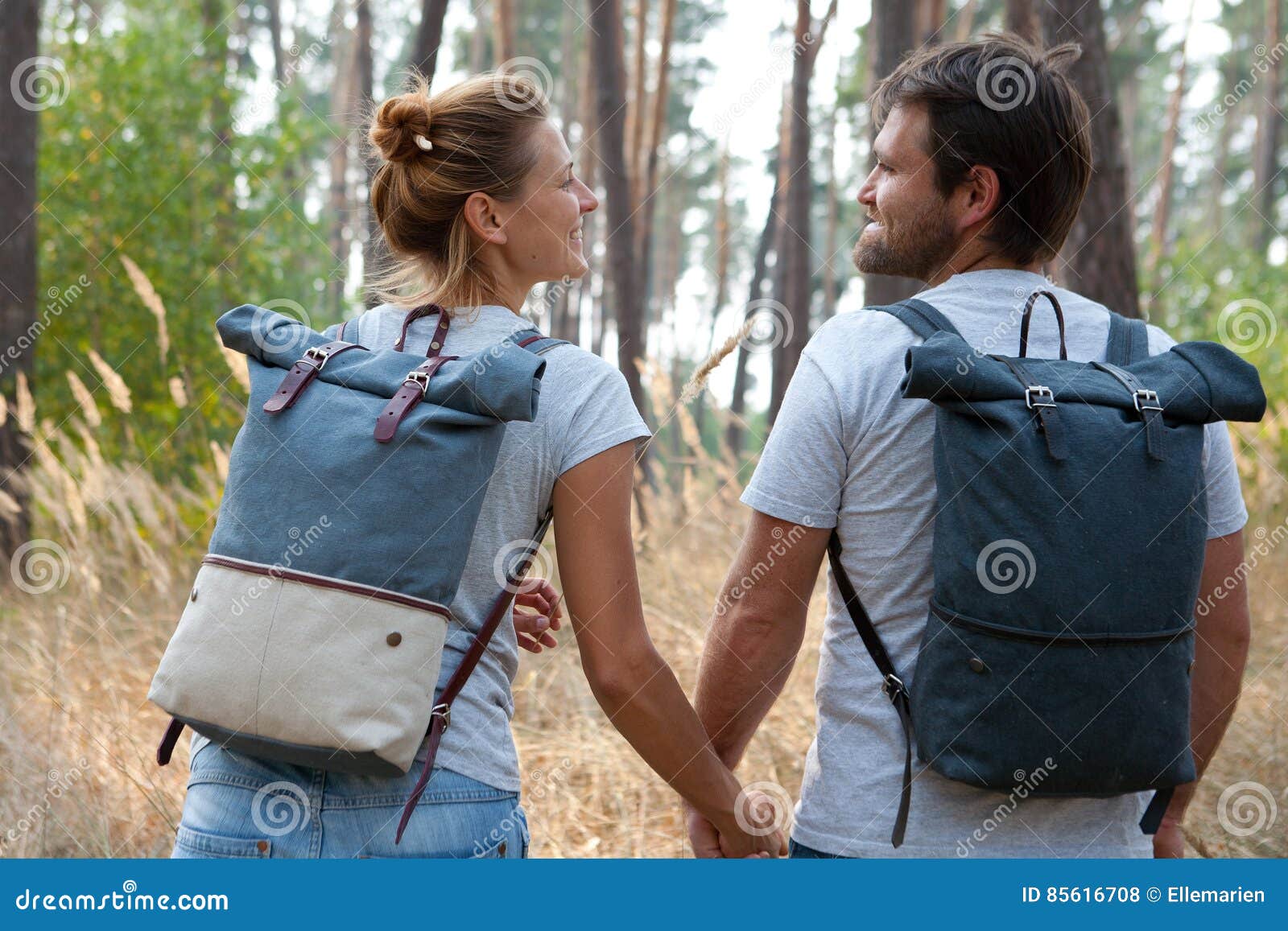 Young Stylish Couple with Backpacks Hugging in Forest Stock Photo ...