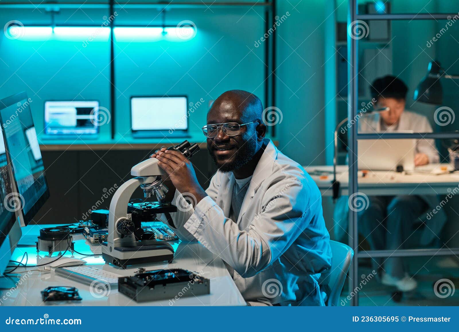 Young Successful Researcher with Microscope Sitting by Workplace Stock ...
