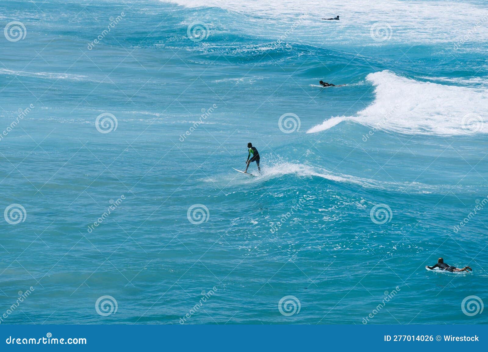 Young Surfer Catching a Wave on a Board in the Vastness of the Ocean ...