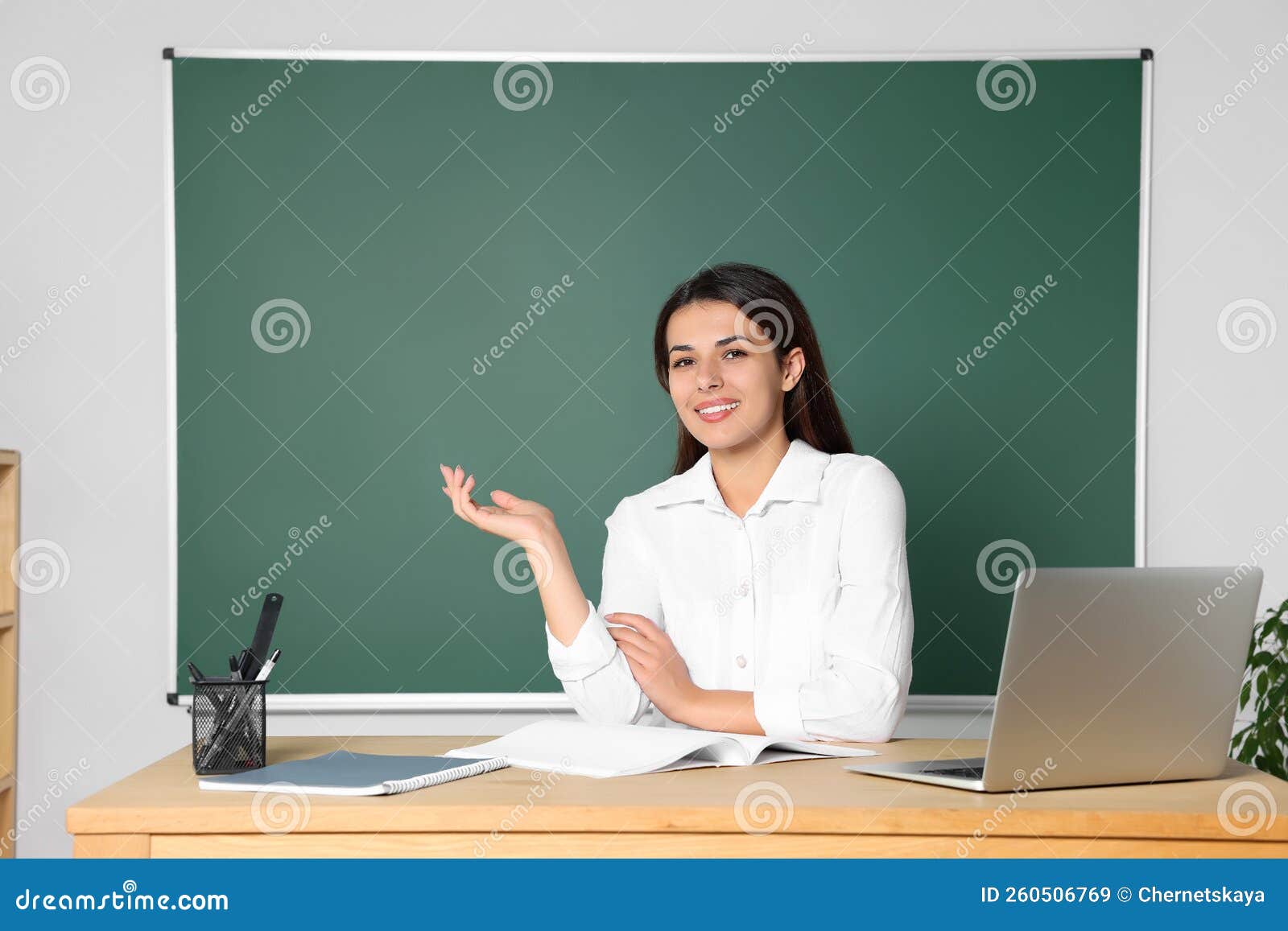 Young Teacher Giving Lesson at Table in Classroom Stock Image - Image ...
