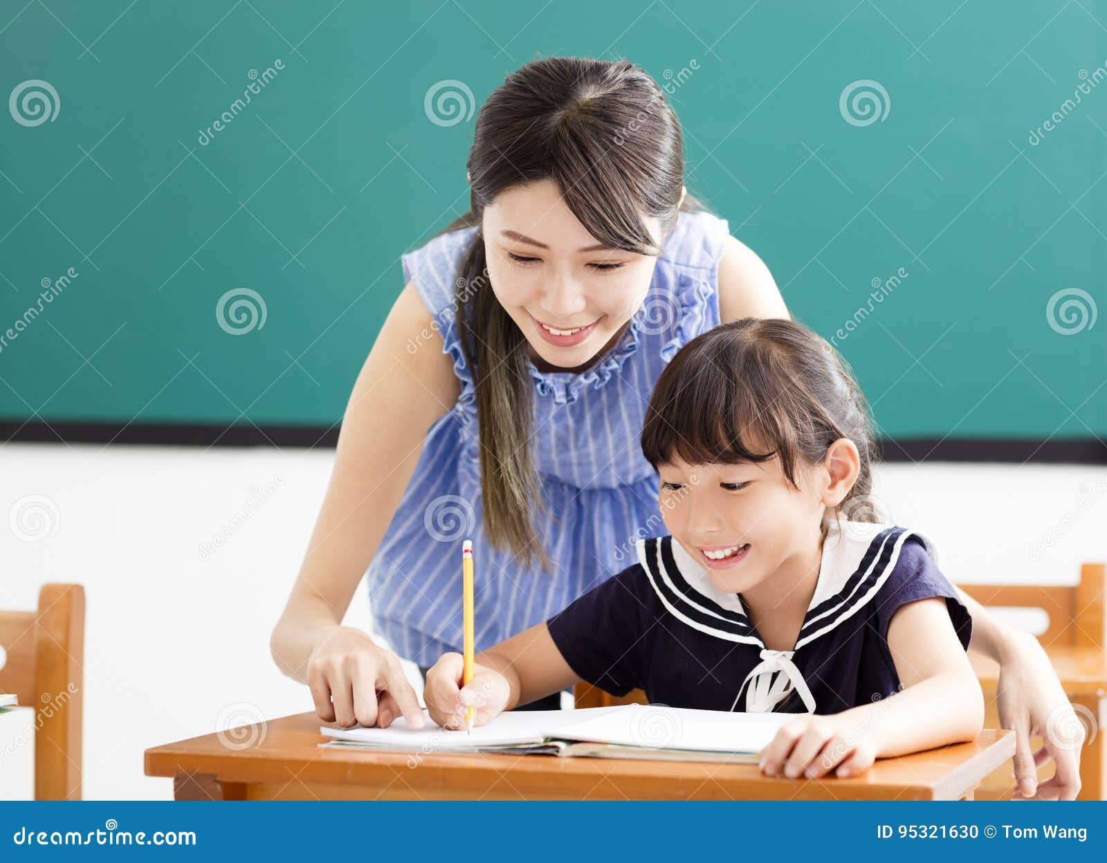 Young Teacher Helping Child with Writing Lesson Stock Photo - Image of ...