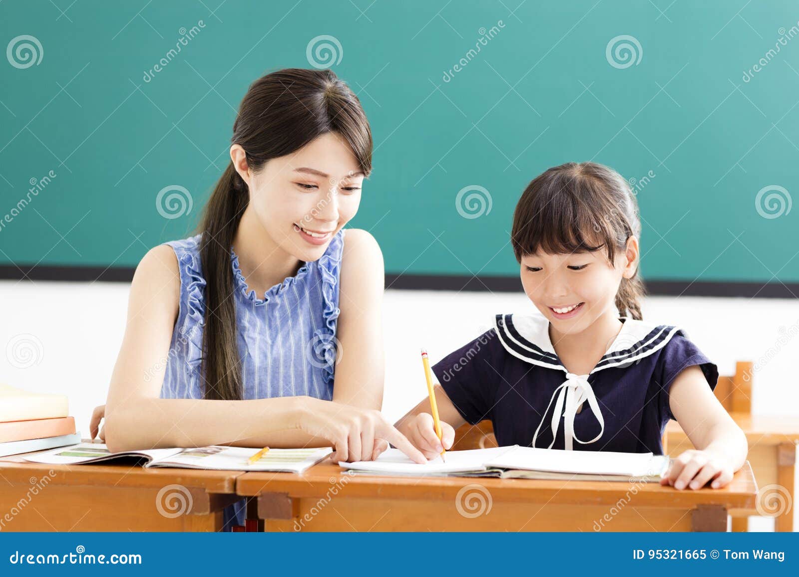 Young Teacher Helping Child with Writing Lesson Stock Image - Image of ...