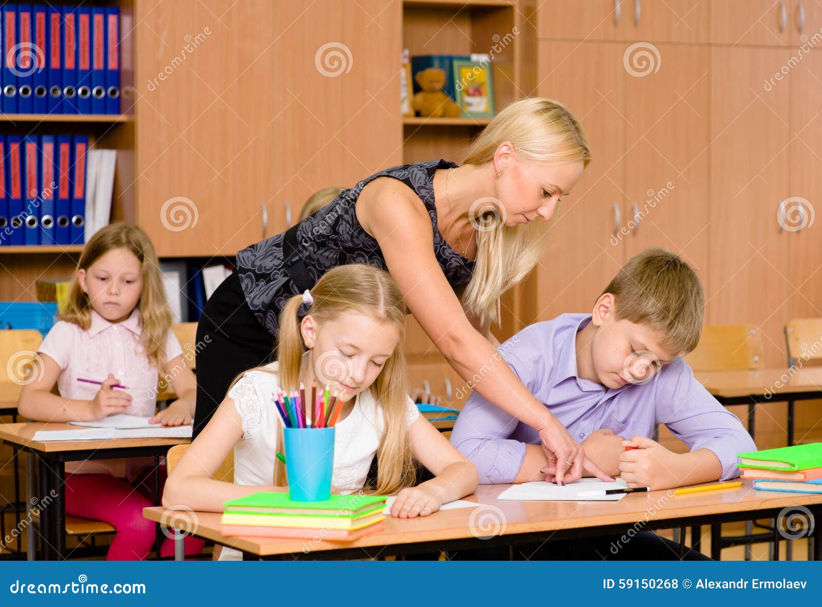 Young Teacher Helps Students of Primary School in the Exam Stock Photo ...